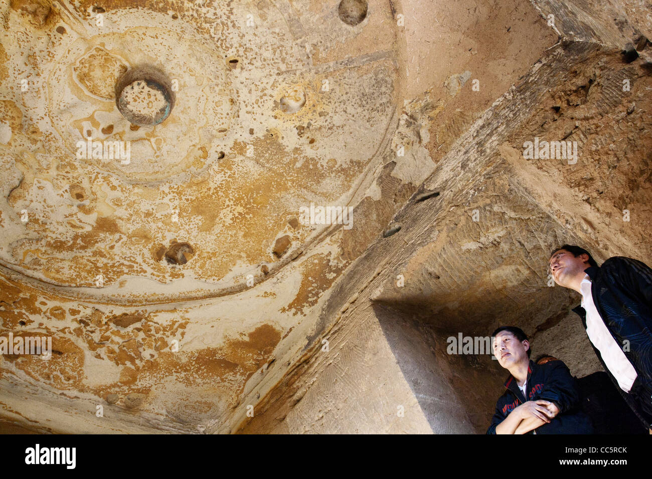 Men looking the ancient caisson ceiling, Red Stone Gorge, Yulin ...