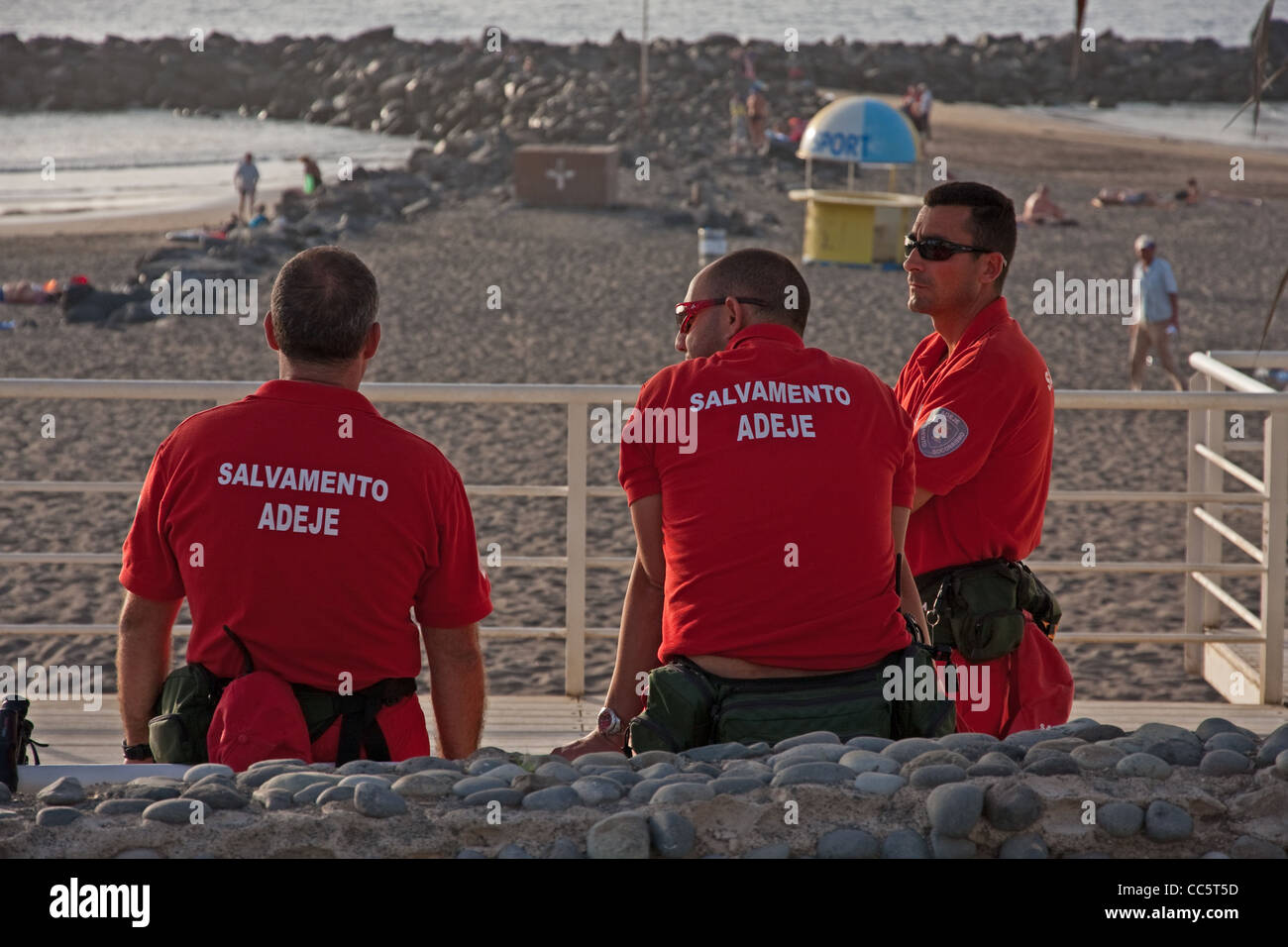 3 lifeguards looking out over beach Stock Photo - Alamy