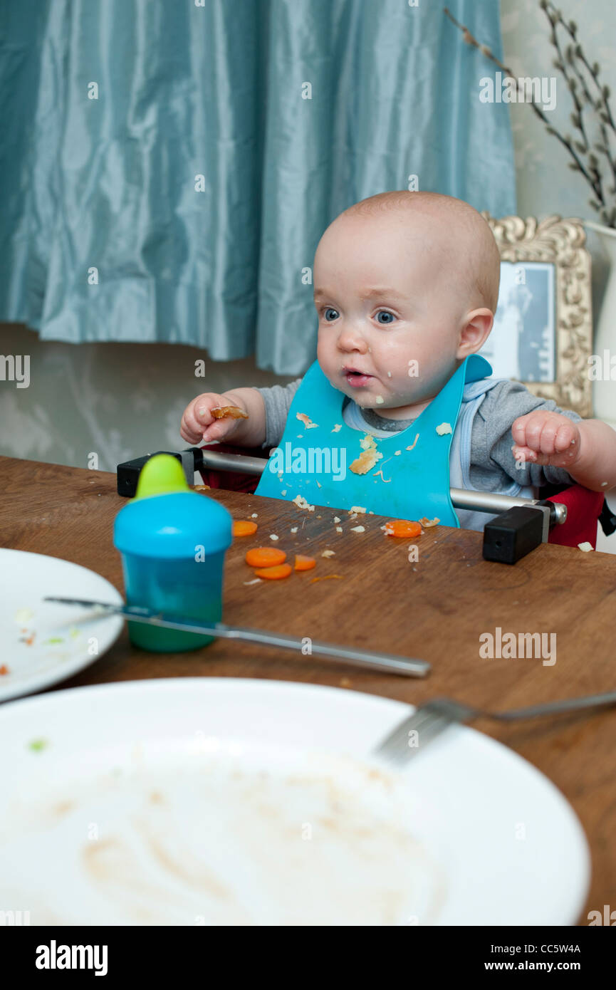 Baby boy feeding himself Stock Photo - Alamy