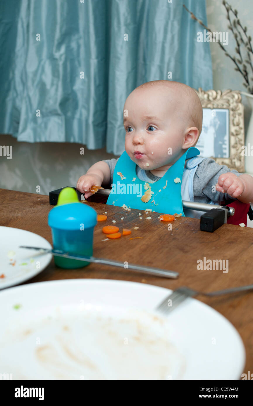 Baby boy feeding himself Stock Photo - Alamy