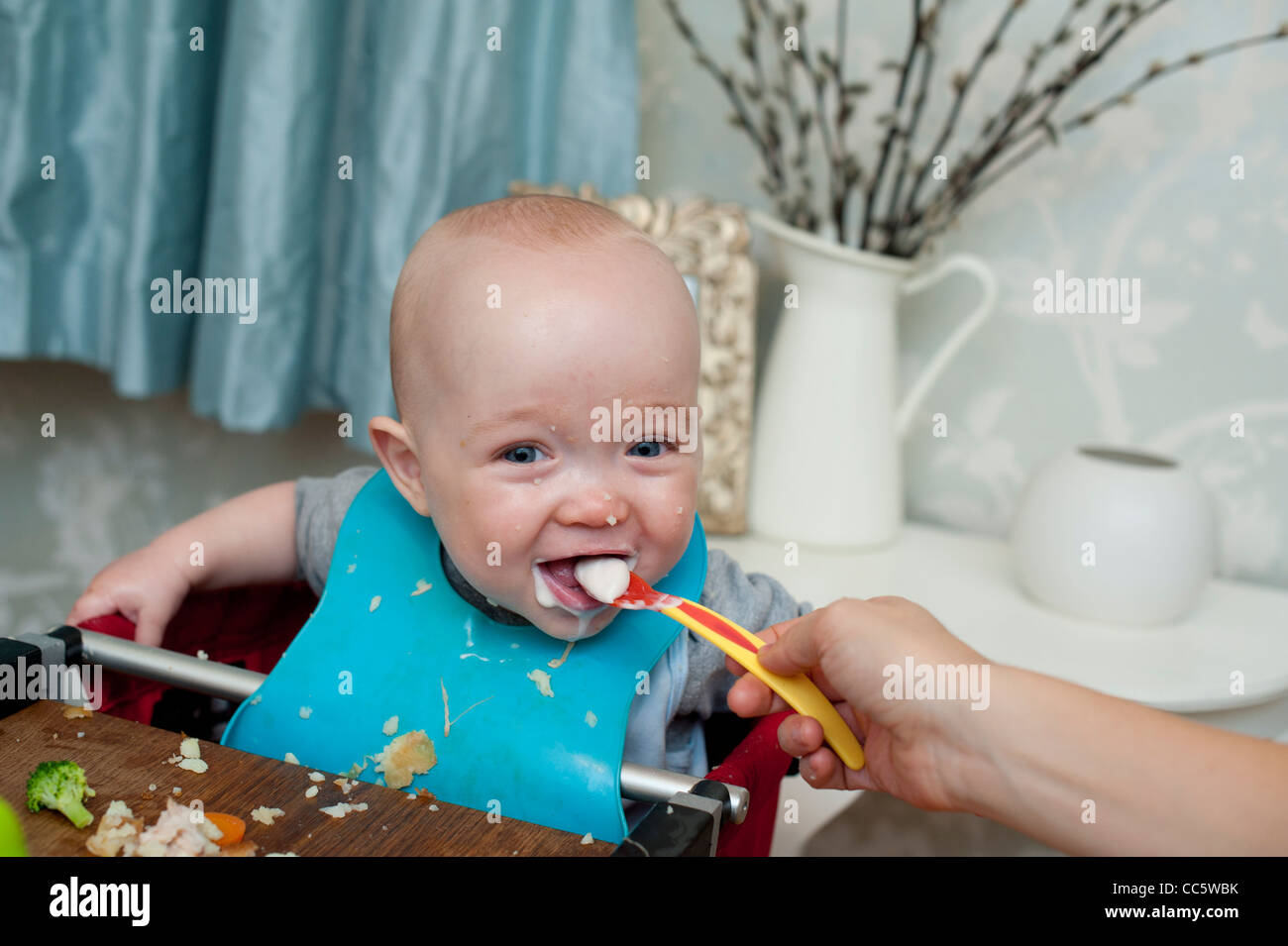 Baby boy feeding himself Stock Photo - Alamy