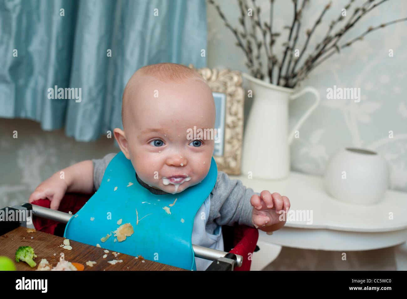 Baby boy feeding himself Stock Photo - Alamy