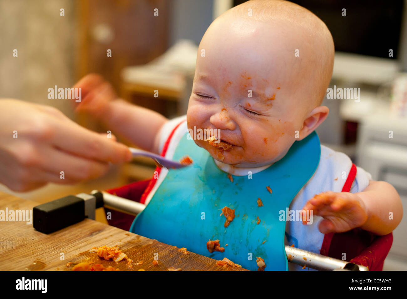 Baby boy feeding himself Stock Photo - Alamy