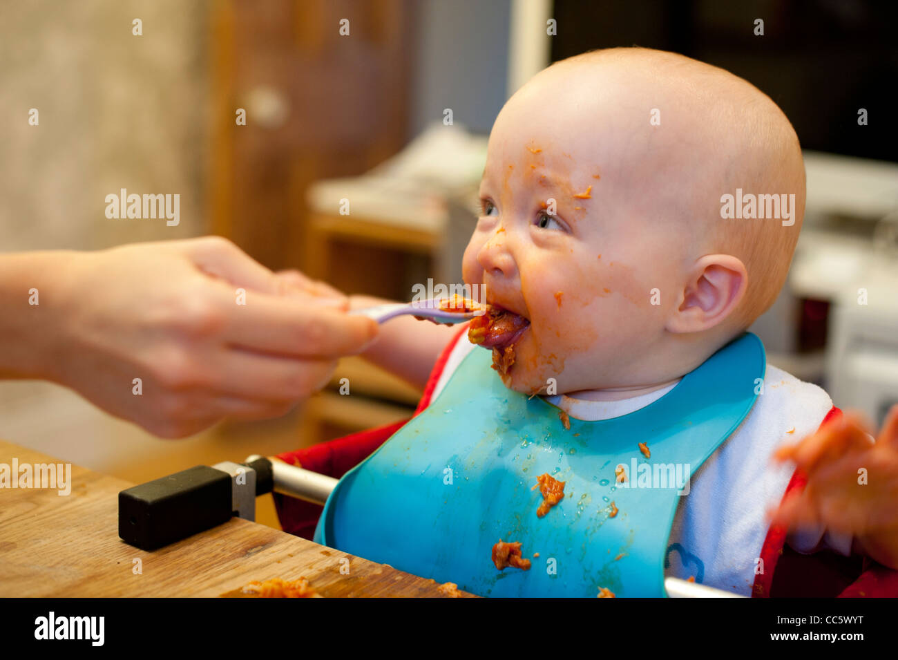 Baby boy feeding himself Stock Photo - Alamy