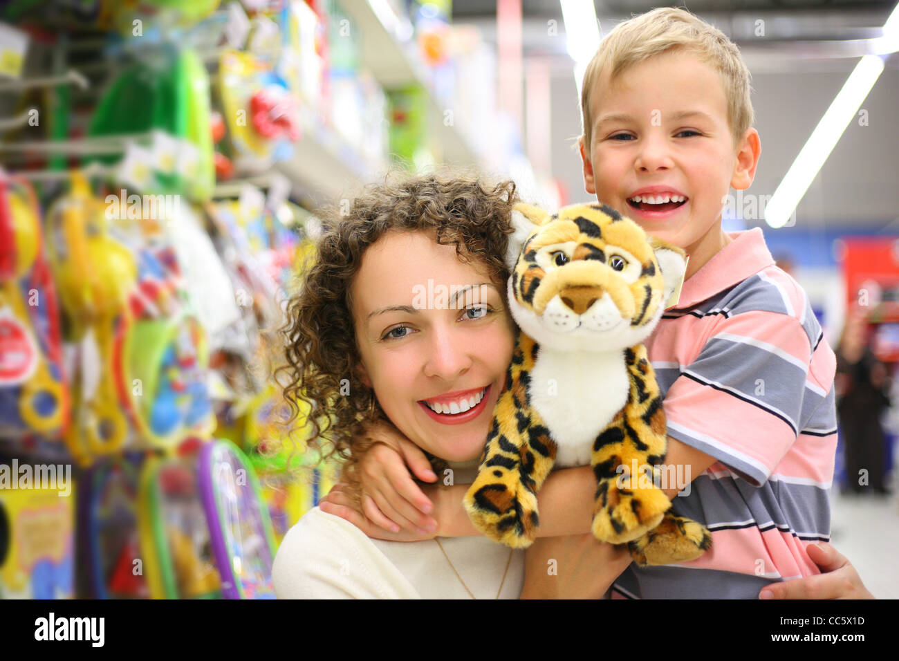 Mother and son with soft toy in shop Stock Photo - Alamy