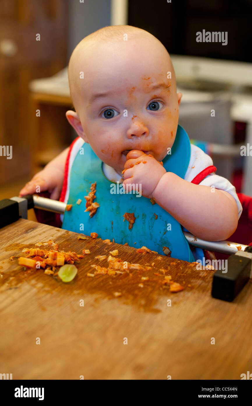 Baby boy feeding himself Stock Photo - Alamy