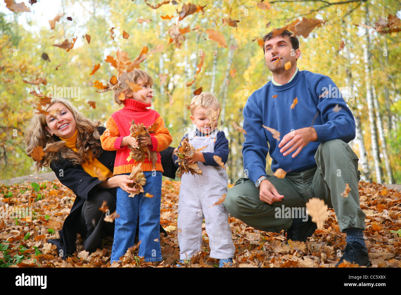 family of four throw autumnal leaves Stock Photo - Alamy