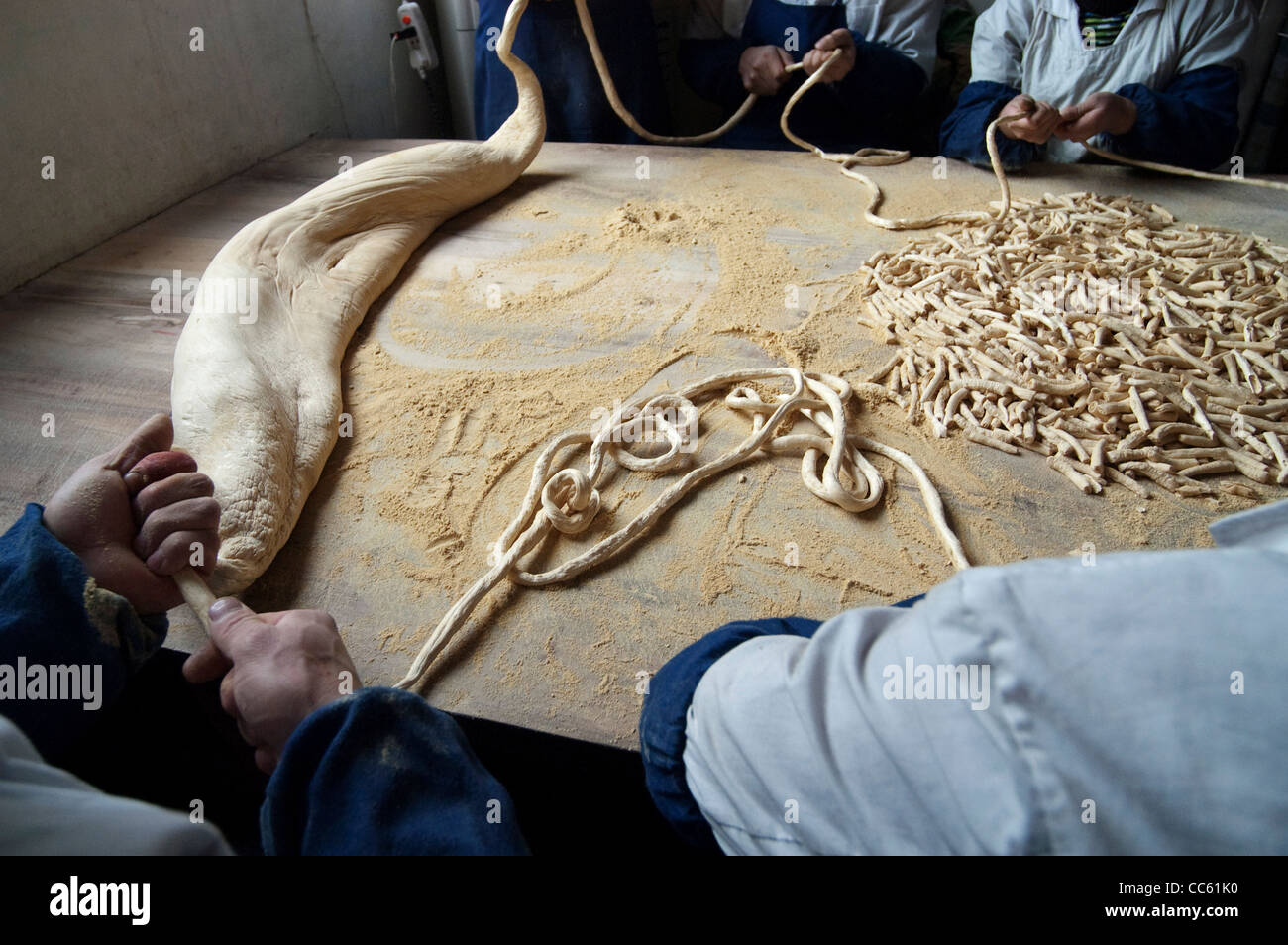 People kneading dough into strips for making crunchy candy, Yunnan ...
