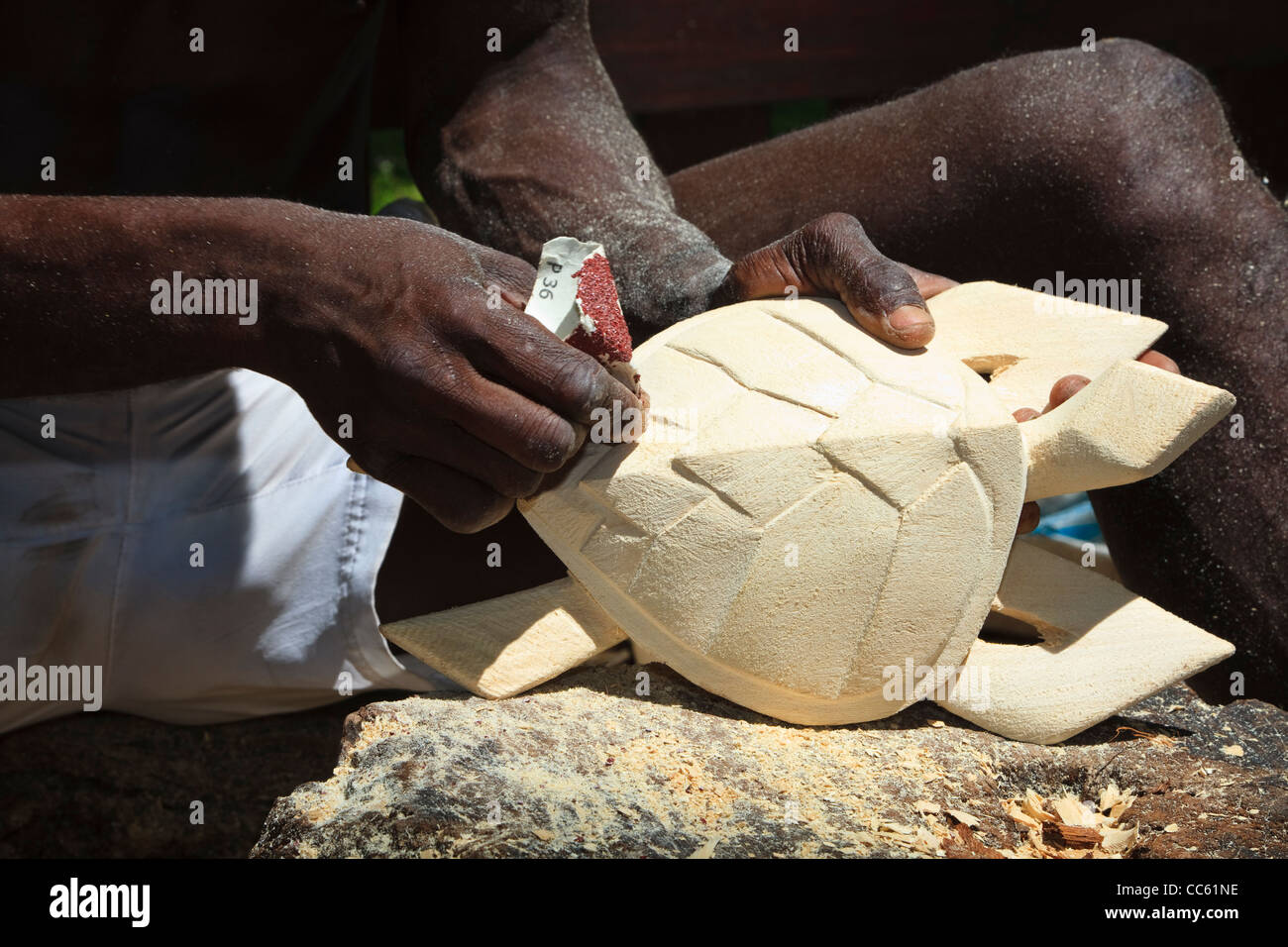 Local craftsman making a model of a turtle from a piece of hard wood ...