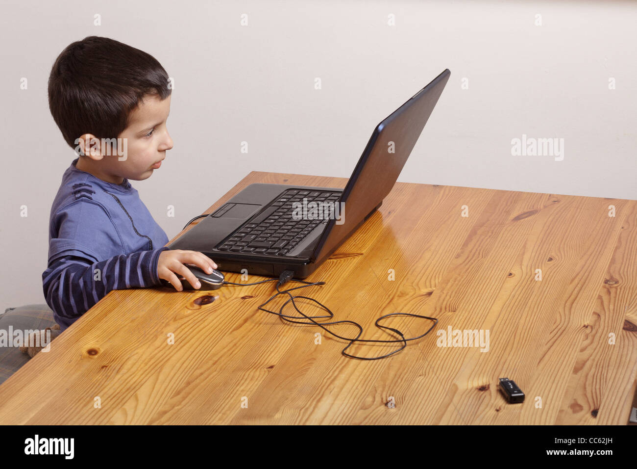 Young boy playing games on a computer alone Stock Photo - Alamy
