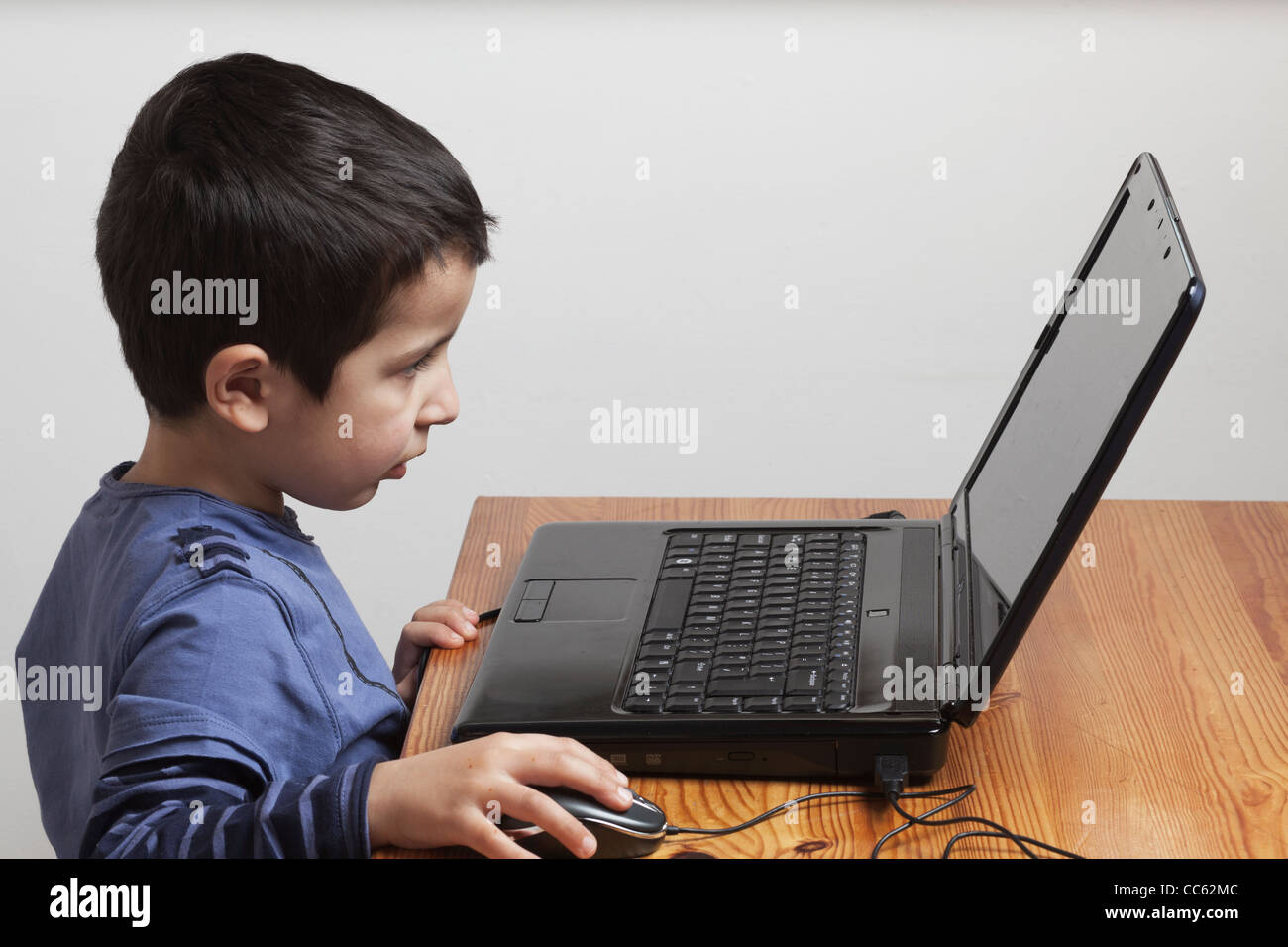 Young boy playing games on a computer alone Stock Photo - Alamy