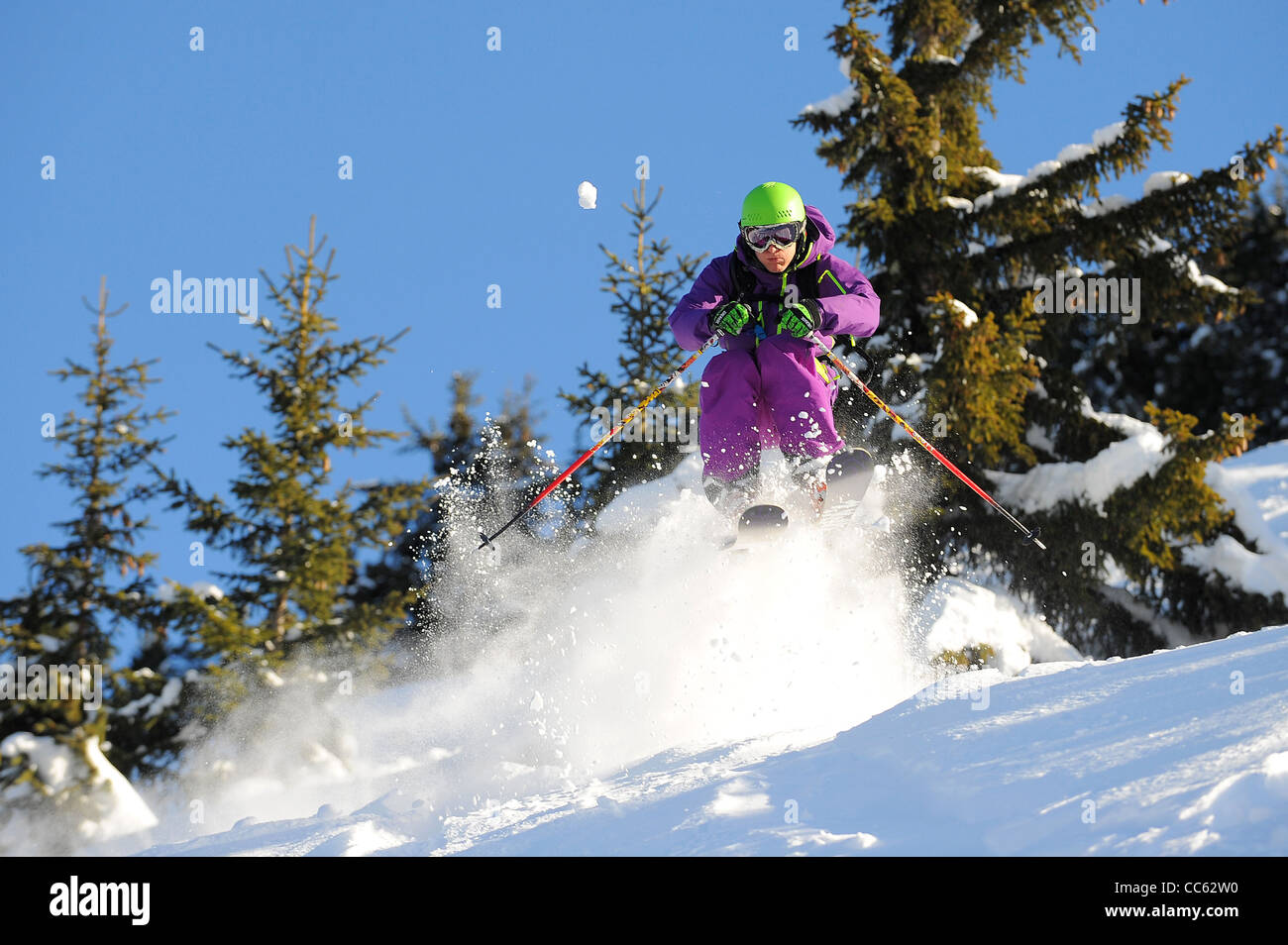 A skier jumps through fresh powder snow, off piste in the ski resort of ...
