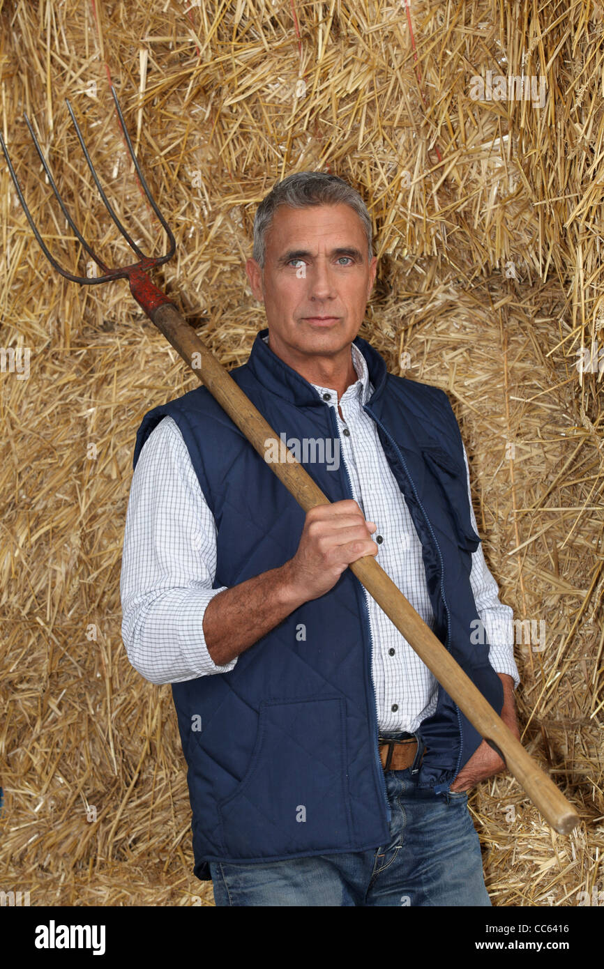 Farmer holding a pitchfork Stock Photo - Alamy