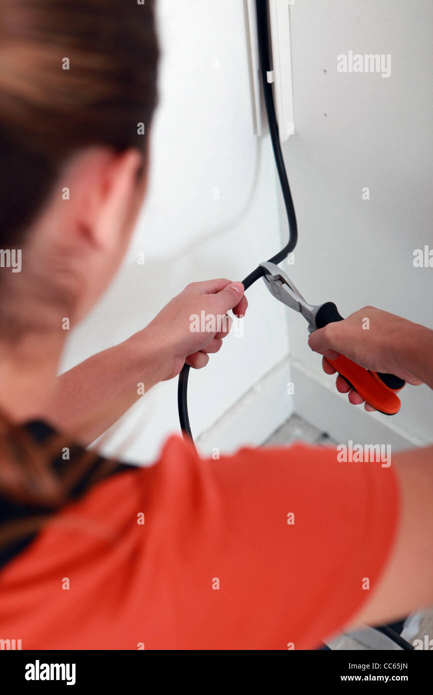 Woman cutting black electrical wire Stock Photo - Alamy