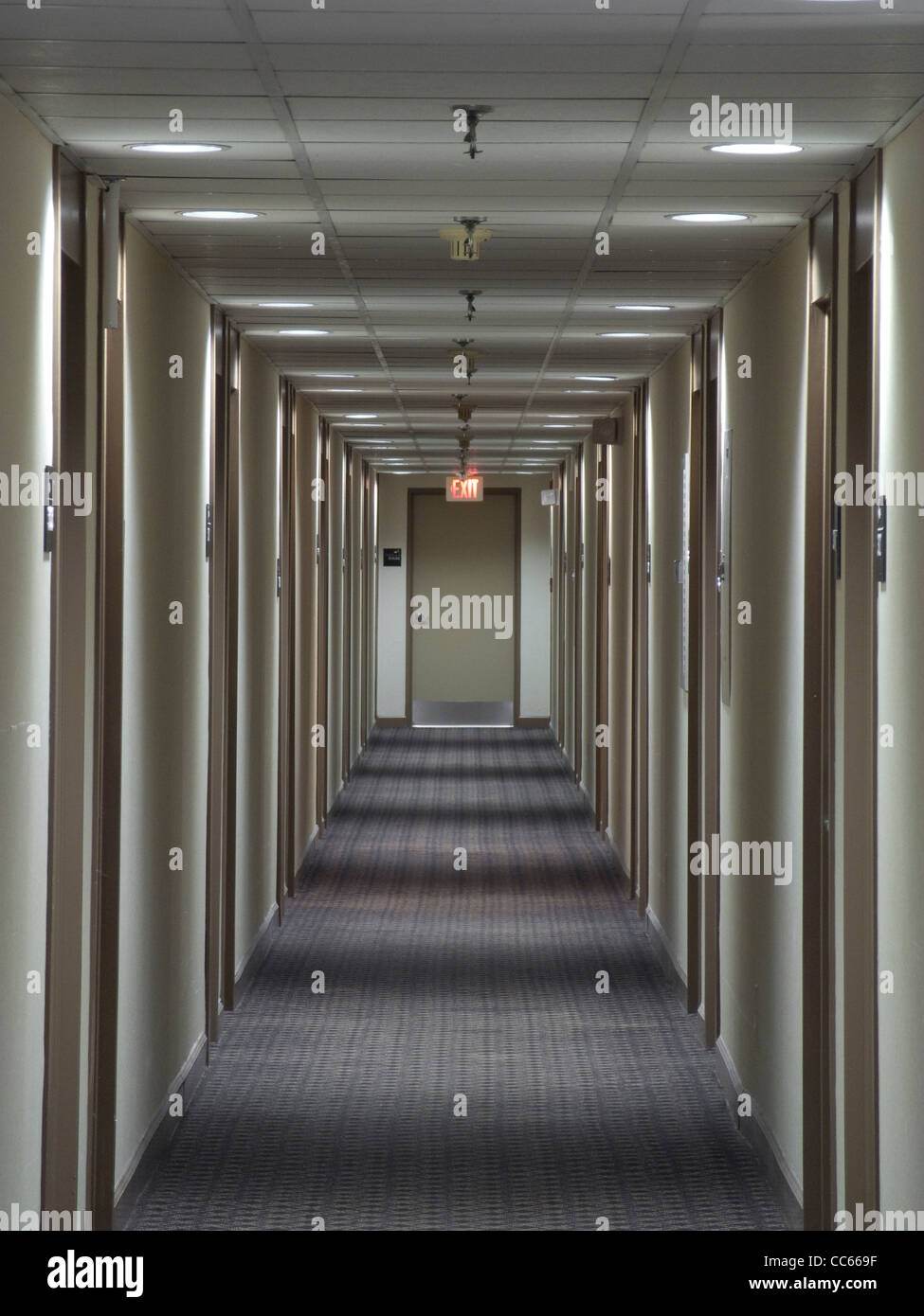 View Down A Long Empty Hotel Corridor, With Exit Sign Stock Photo - Alamy