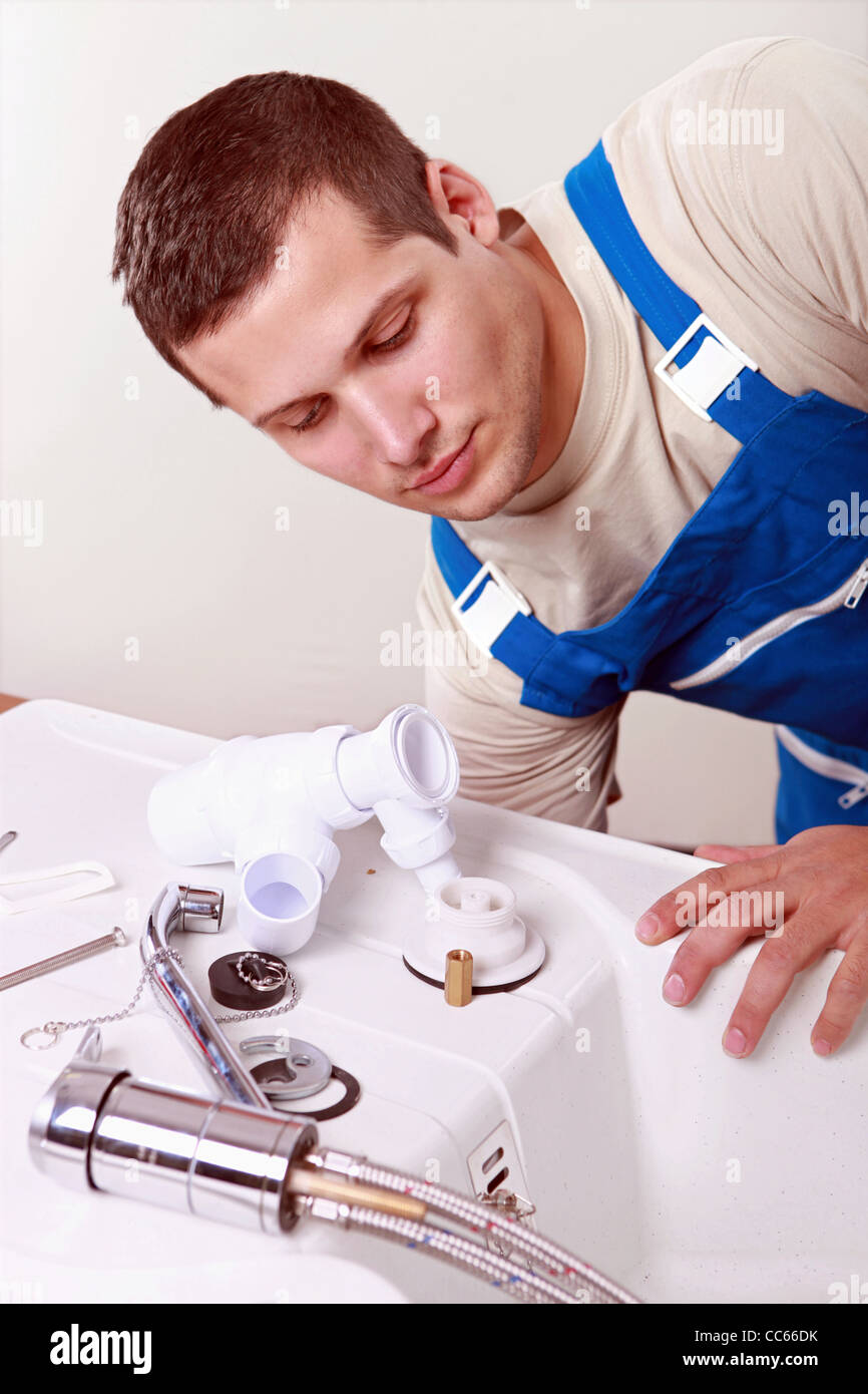 Plumber fixing a sink Stock Photo - Alamy