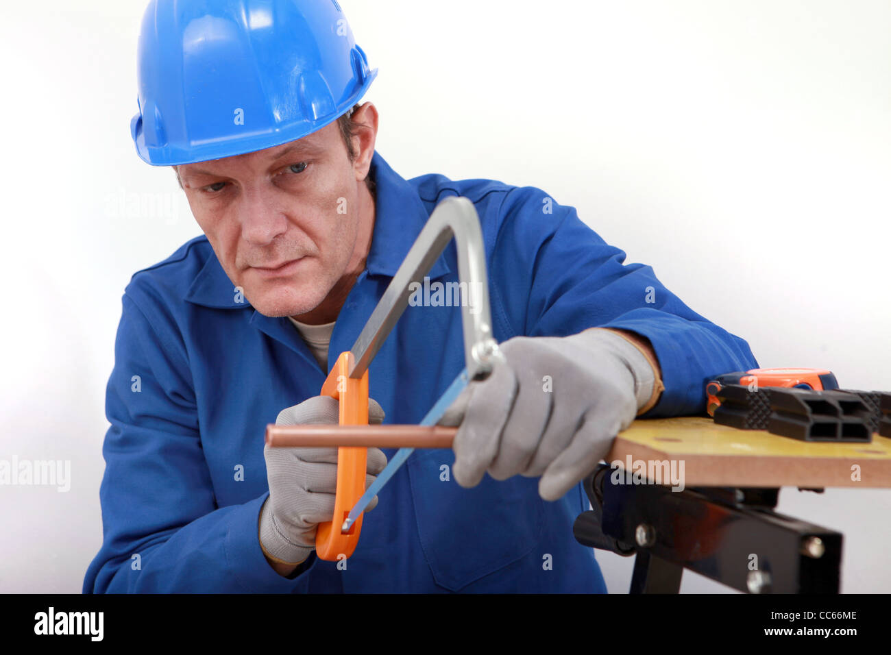 Laborer sawing copper pipe Stock Photo - Alamy