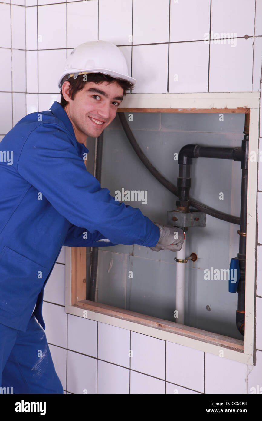 Young plumber working in bathroom Stock Photo - Alamy