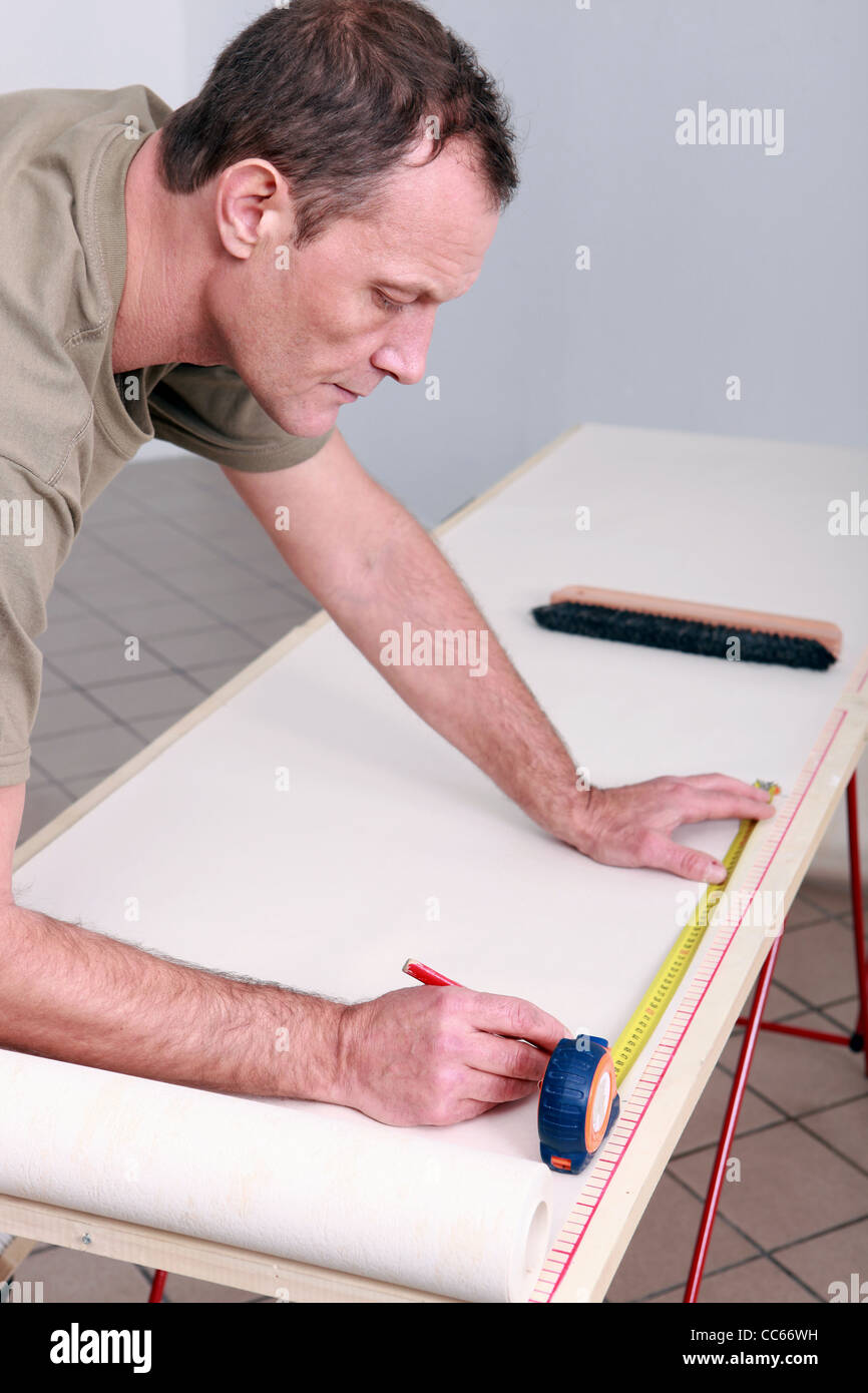 Man measuring wallpaper Stock Photo - Alamy