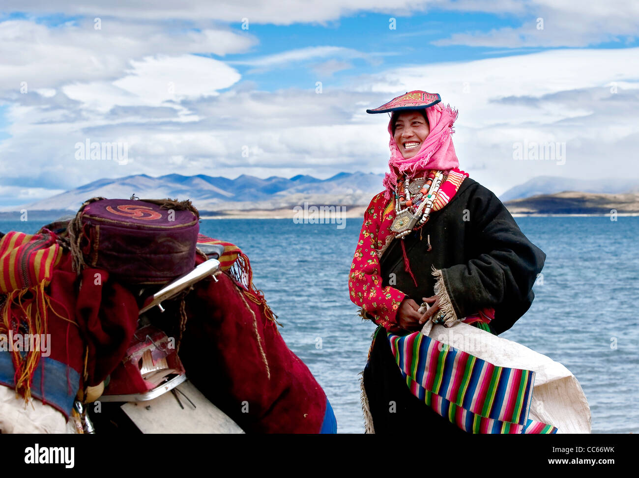 Tibetan woman in traditional costume beside Lake Tangra Yumco, Ngari ...
