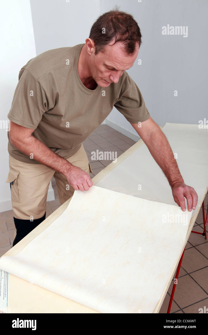 Decorator using a wallpaper table Stock Photo - Alamy