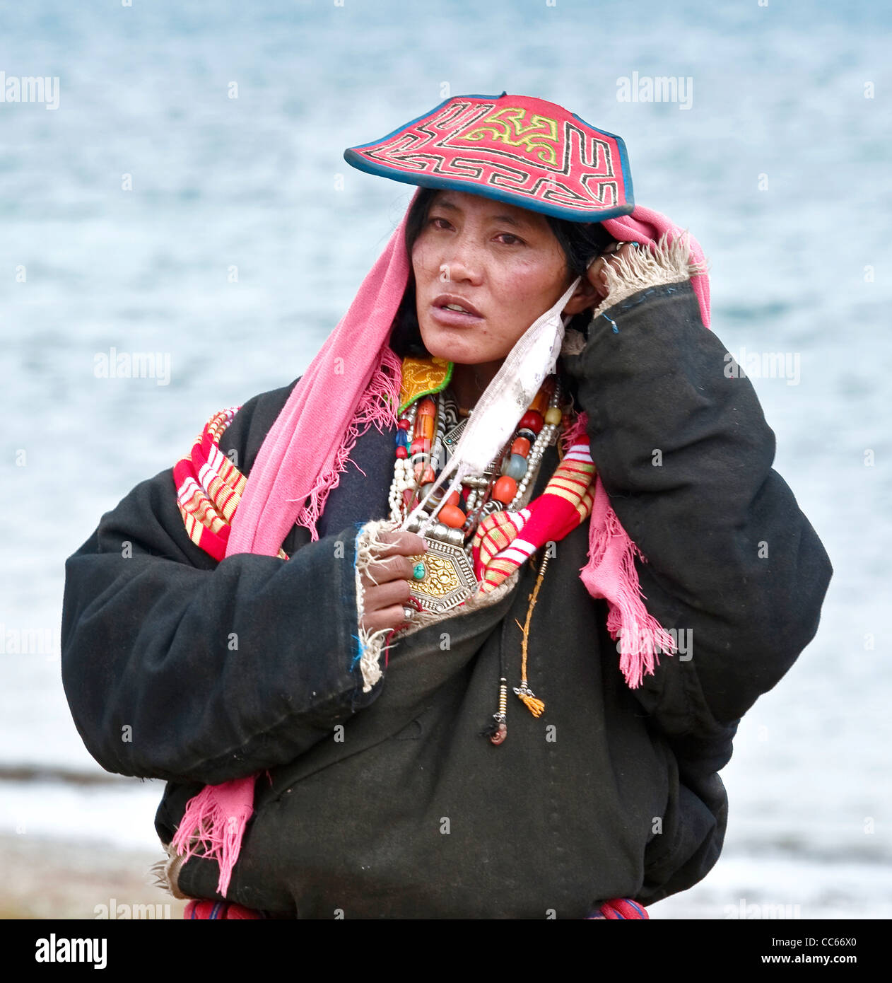 Tibetan woman in traditional costume beside Lake Tangra Yumco, Ngari ...