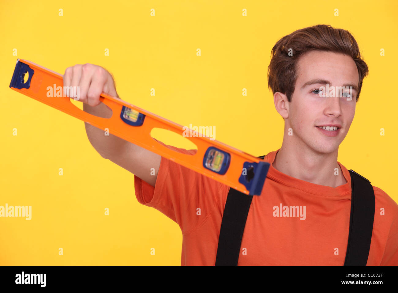 Young man with a spirit level Stock Photo - Alamy