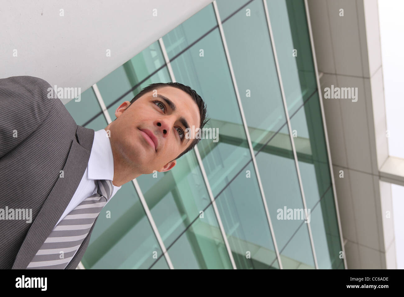 Young executive standing outside a modern office building Stock Photo ...