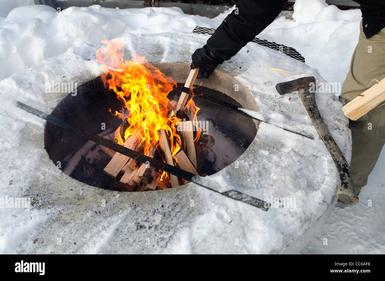 lighting a warming fire at a winter camp Stock Photo - Alamy