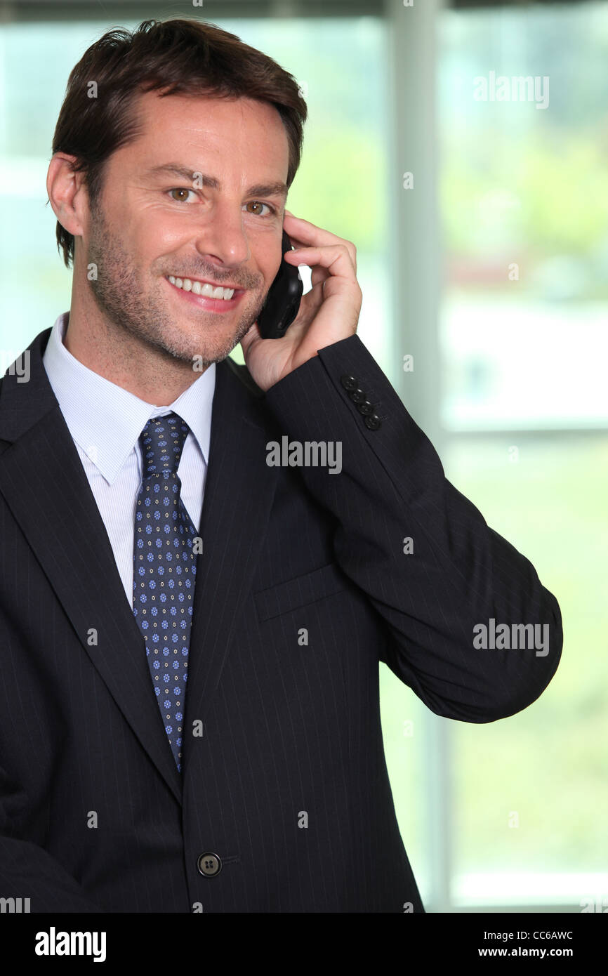 Smiling businessman using a telephone Stock Photo - Alamy