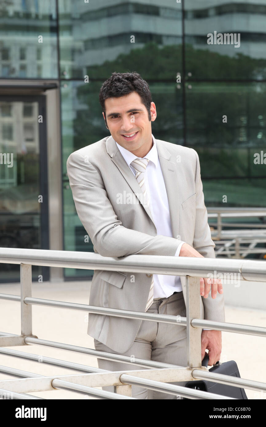 Smiling male executive standing outside an office building Stock Photo ...