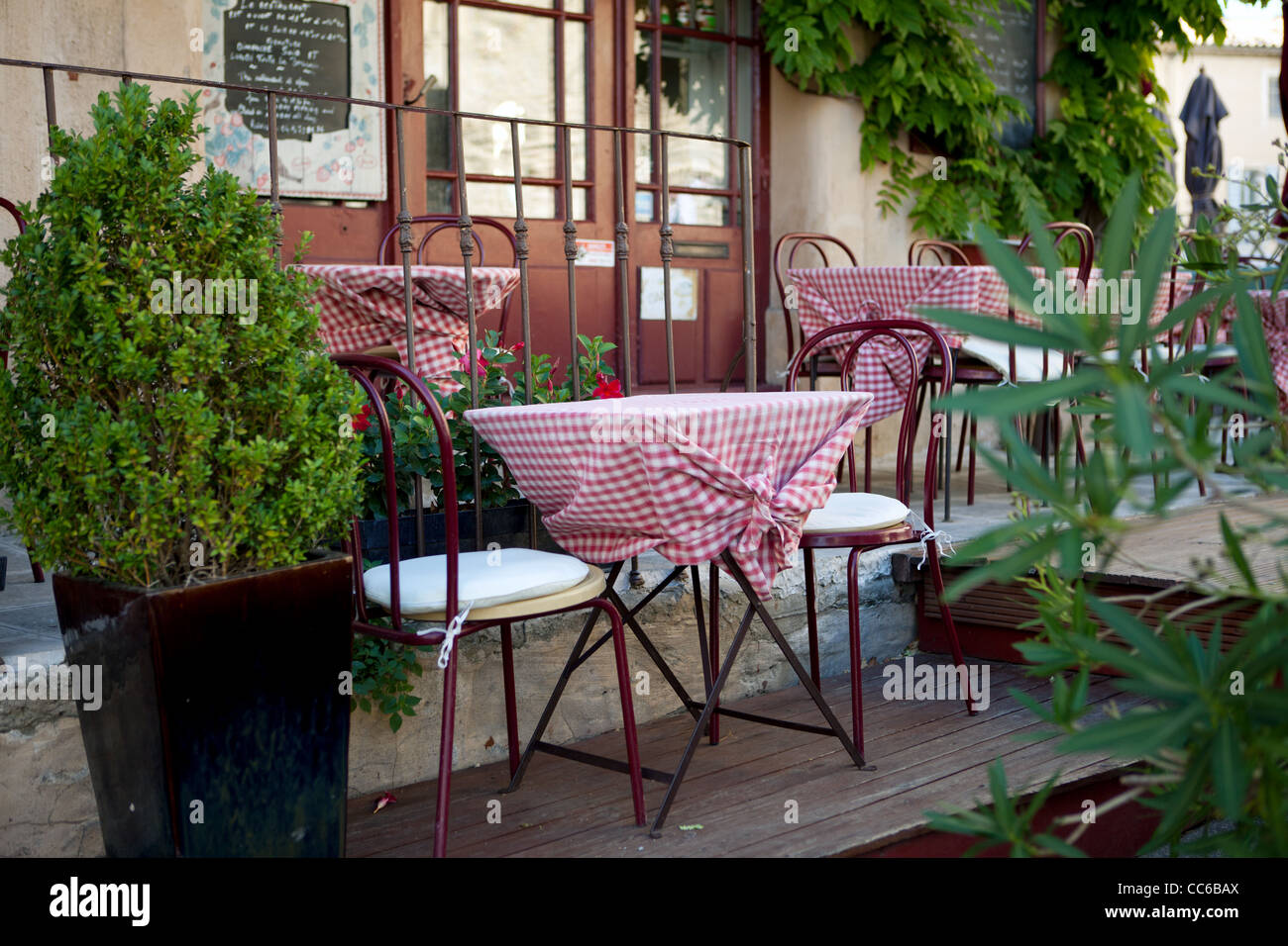 Cafe tables are set & ready for lunch customers at a cafe in Gordes ...