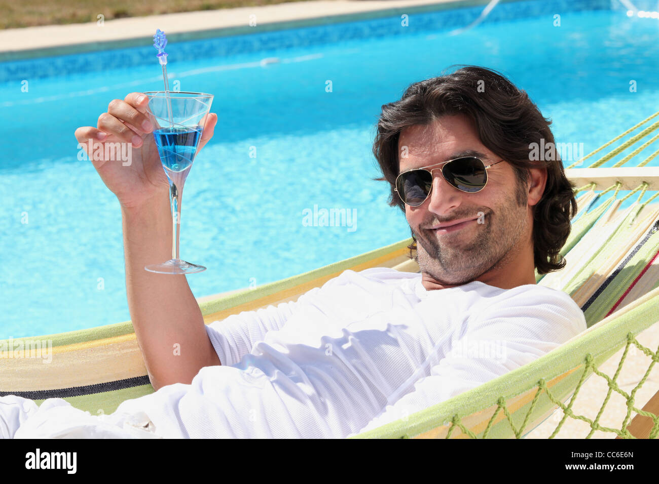 Man relaxing by the pool Stock Photo - Alamy