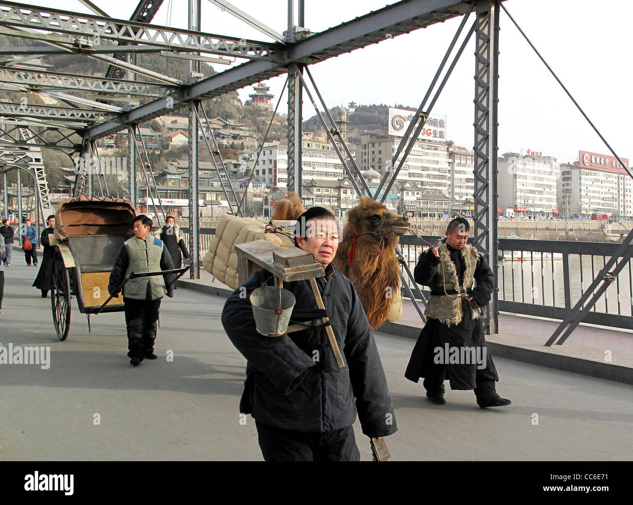 People wearing traditional costume walking on Yellow River Iron Bridge ...
