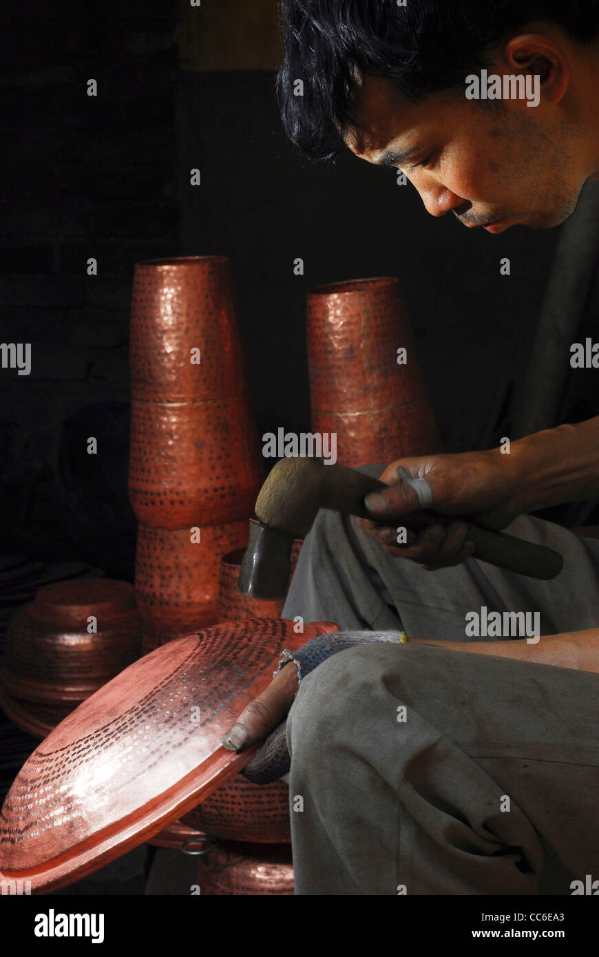 Man shaping a base of bronze pot, Liangshan, Sichuan , China Stock ...