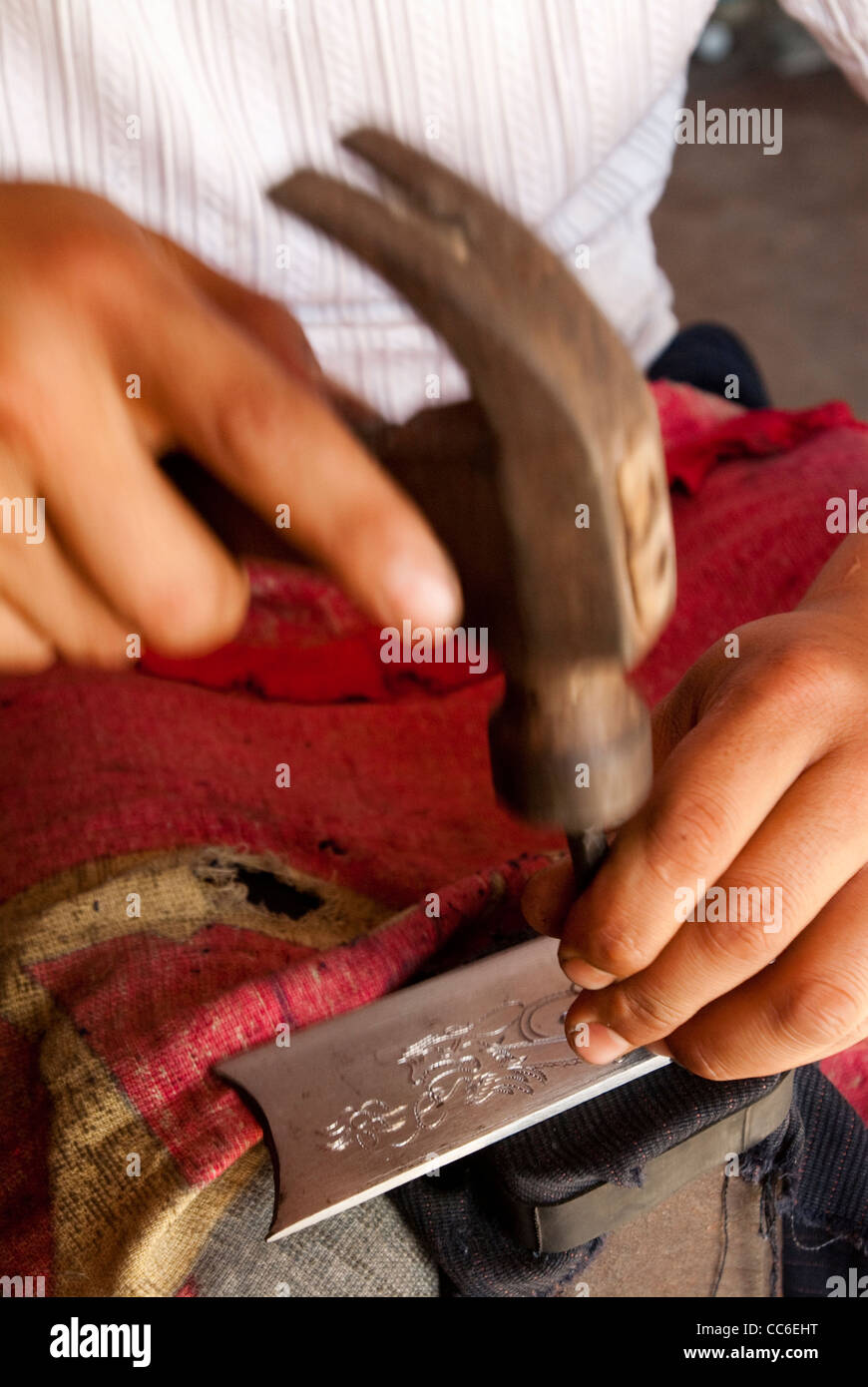 Man engraving patterns on a sword, Dehong, Yunnan , China Stock Photo ...