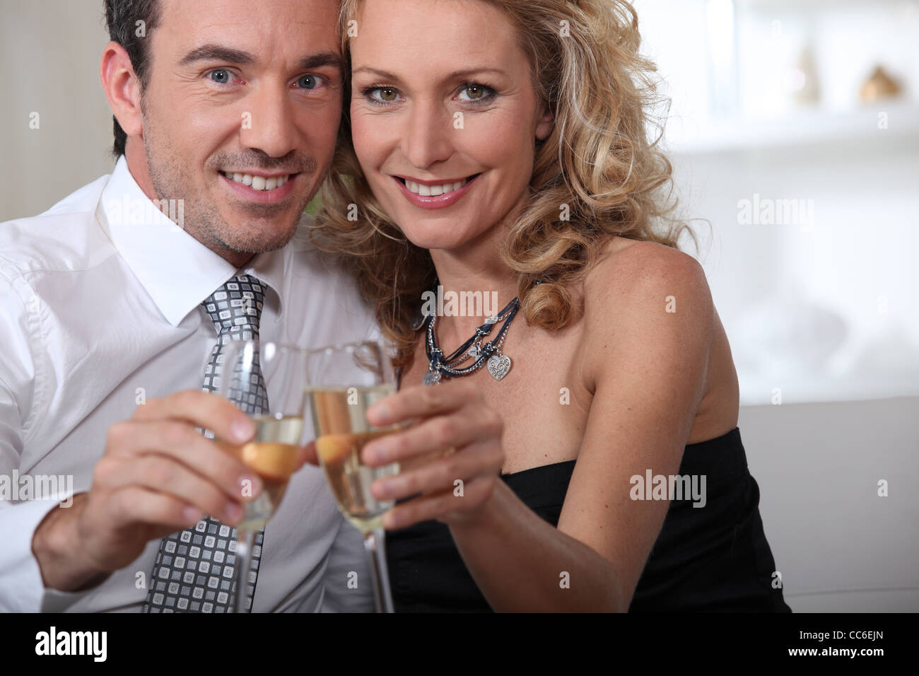 Couple celebrating at home with champagne Stock Photo - Alamy