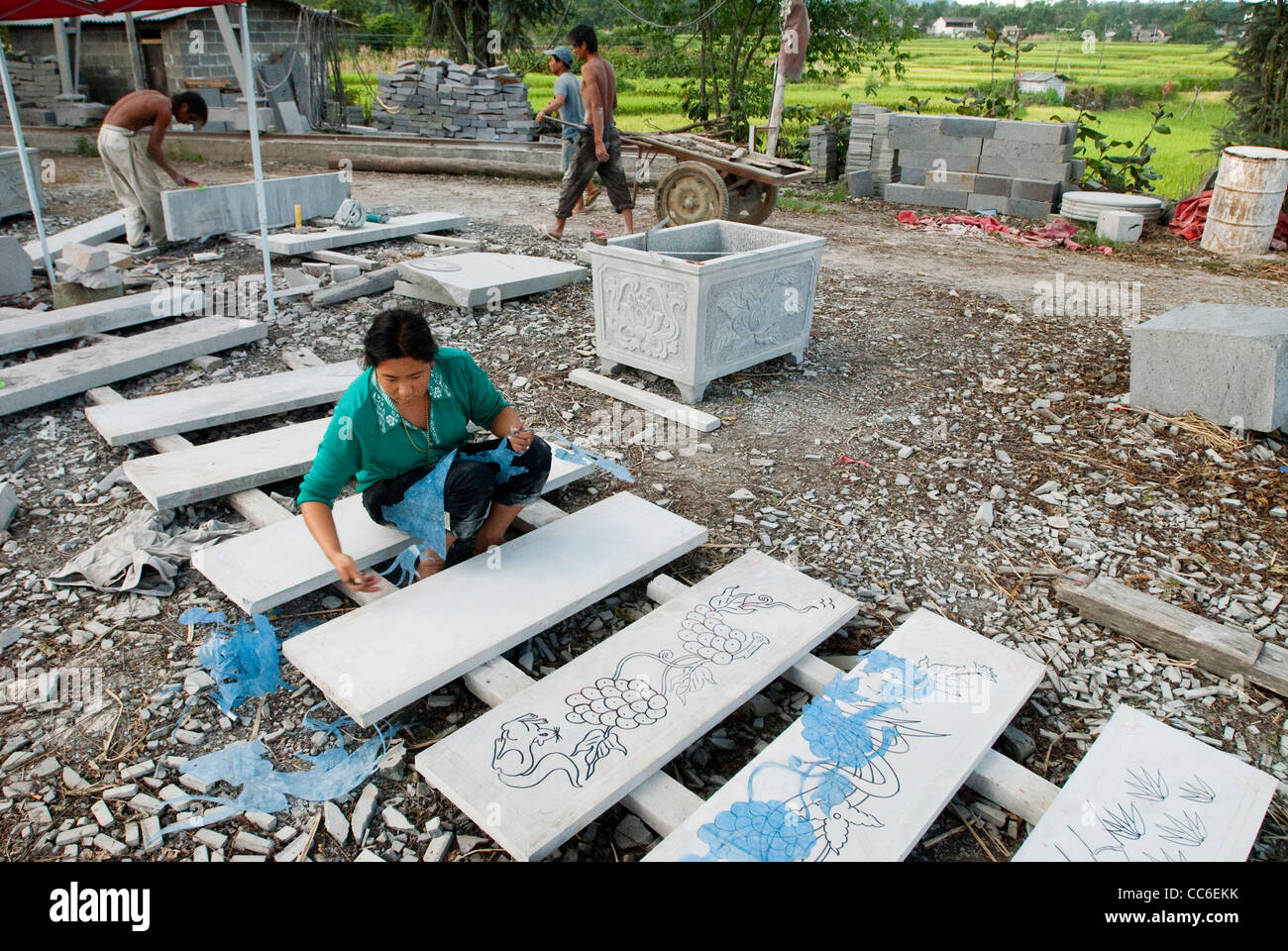 Woman drawing on stone slabs in the stone processing factory, Tengchong ...