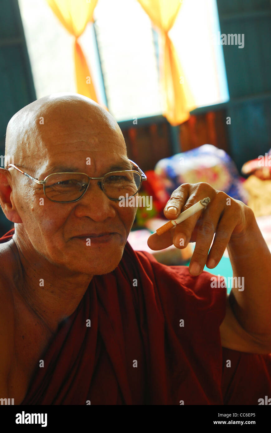 Elderly monk smoking, Hansa Temple, Ruili, Dehong, Yunnan , China Stock ...