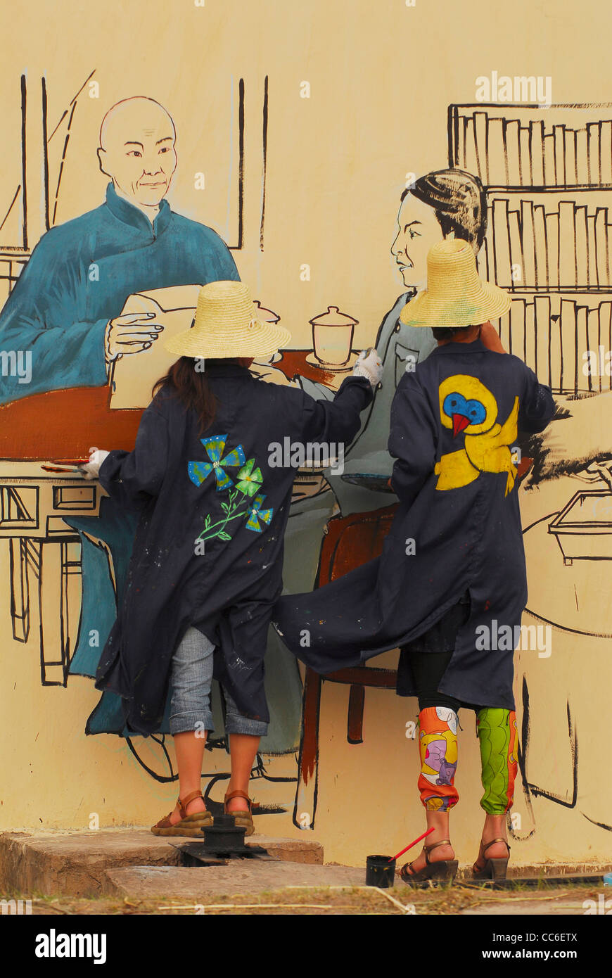 Back view of women painting on the wall, Chuxiong, Yunnan , China Stock ...