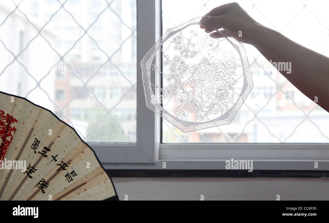 Woman taking a white Chinese paper cutting, Beijing, China Stock Photo ...