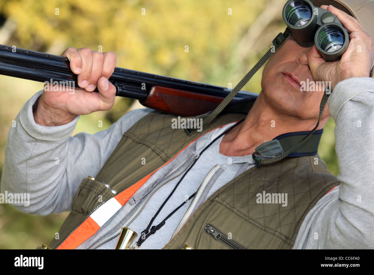 Hunter looking through binoculars Stock Photo - Alamy
