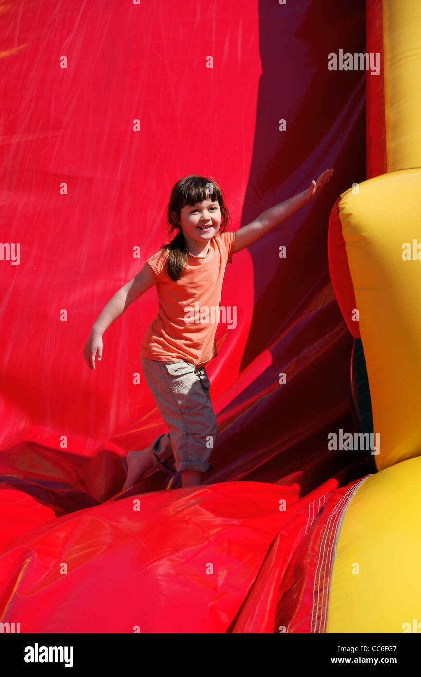 Girl jumping on the colored inflatable slide Stock Photo - Alamy