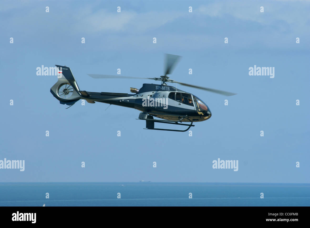 Helicopter flying on blue sky and sea Stock Photo - Alamy