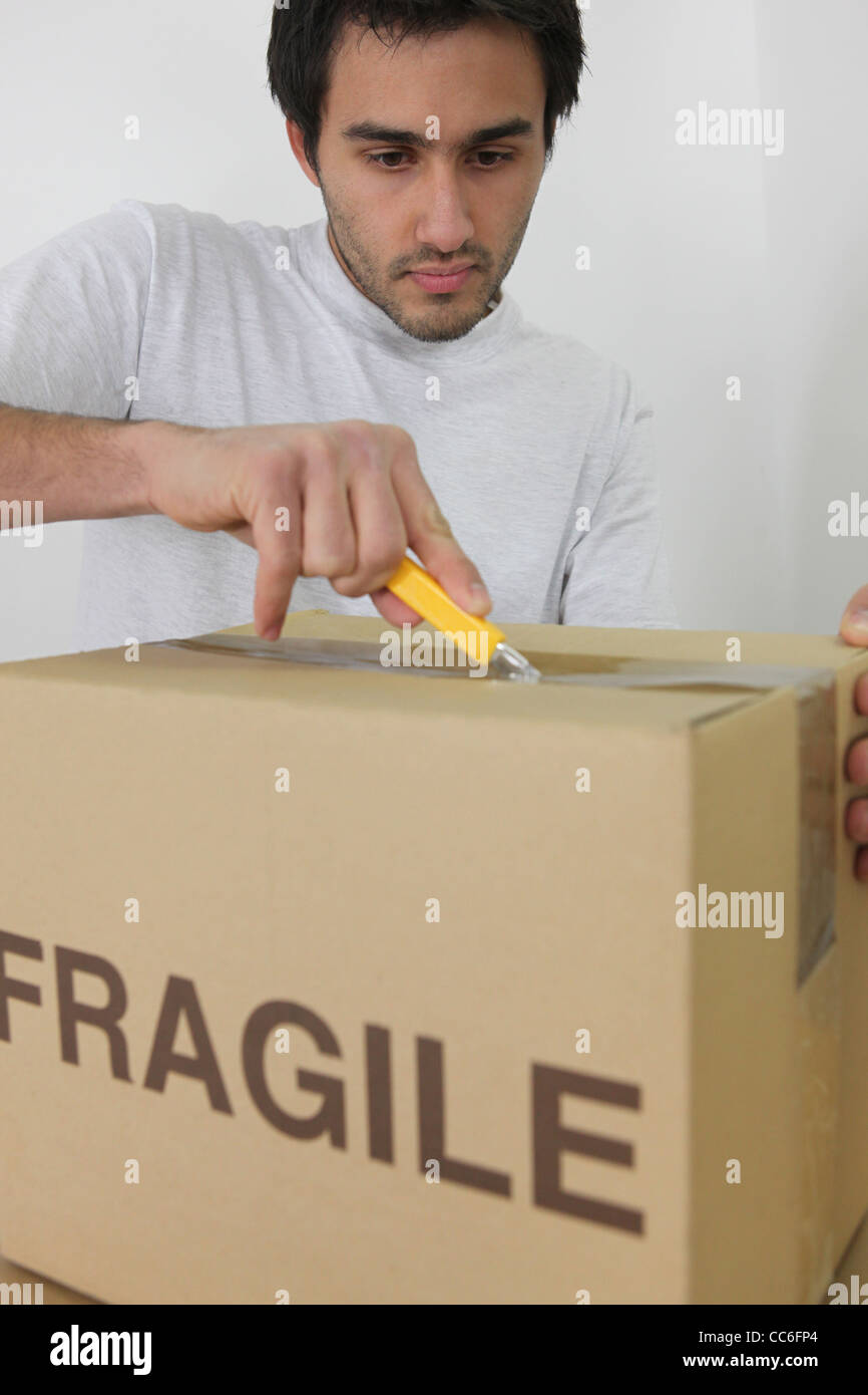 Man unpacking a cardboard box Stock Photo - Alamy