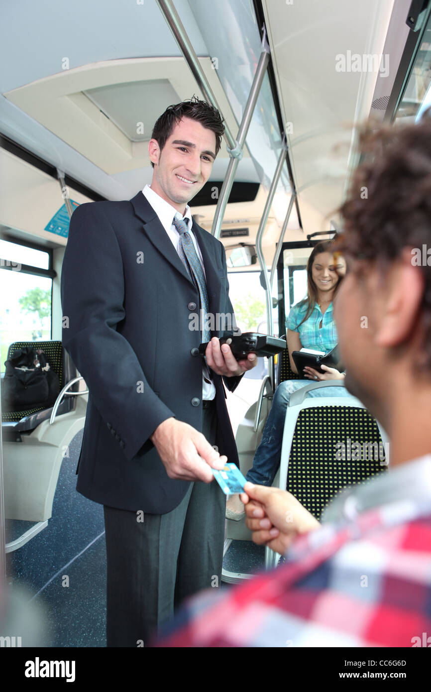 Smiling conductor checking tickets on a tram Stock Photo - Alamy