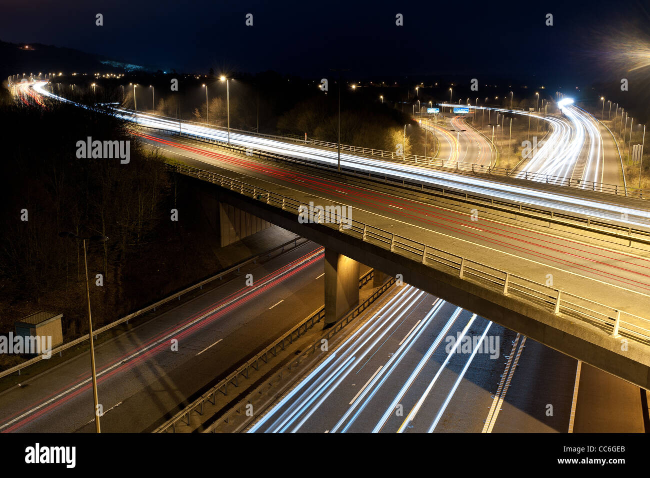 Free flowing motorway traffic at night vehicles have left trails at the ...