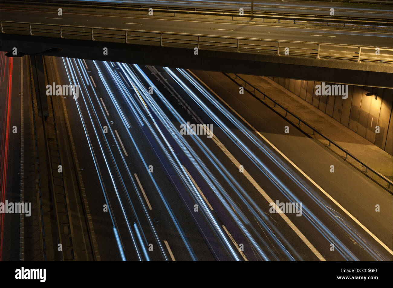 Free flowing motorway traffic at night vehicles have left trails at the ...