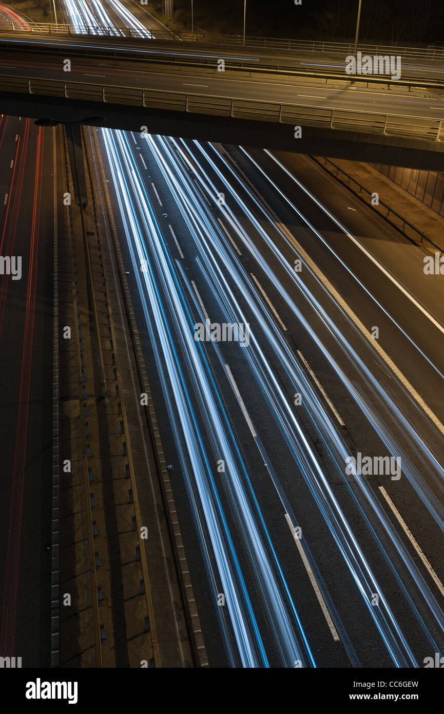 Free flowing motorway traffic at night vehicles have left trails at the ...