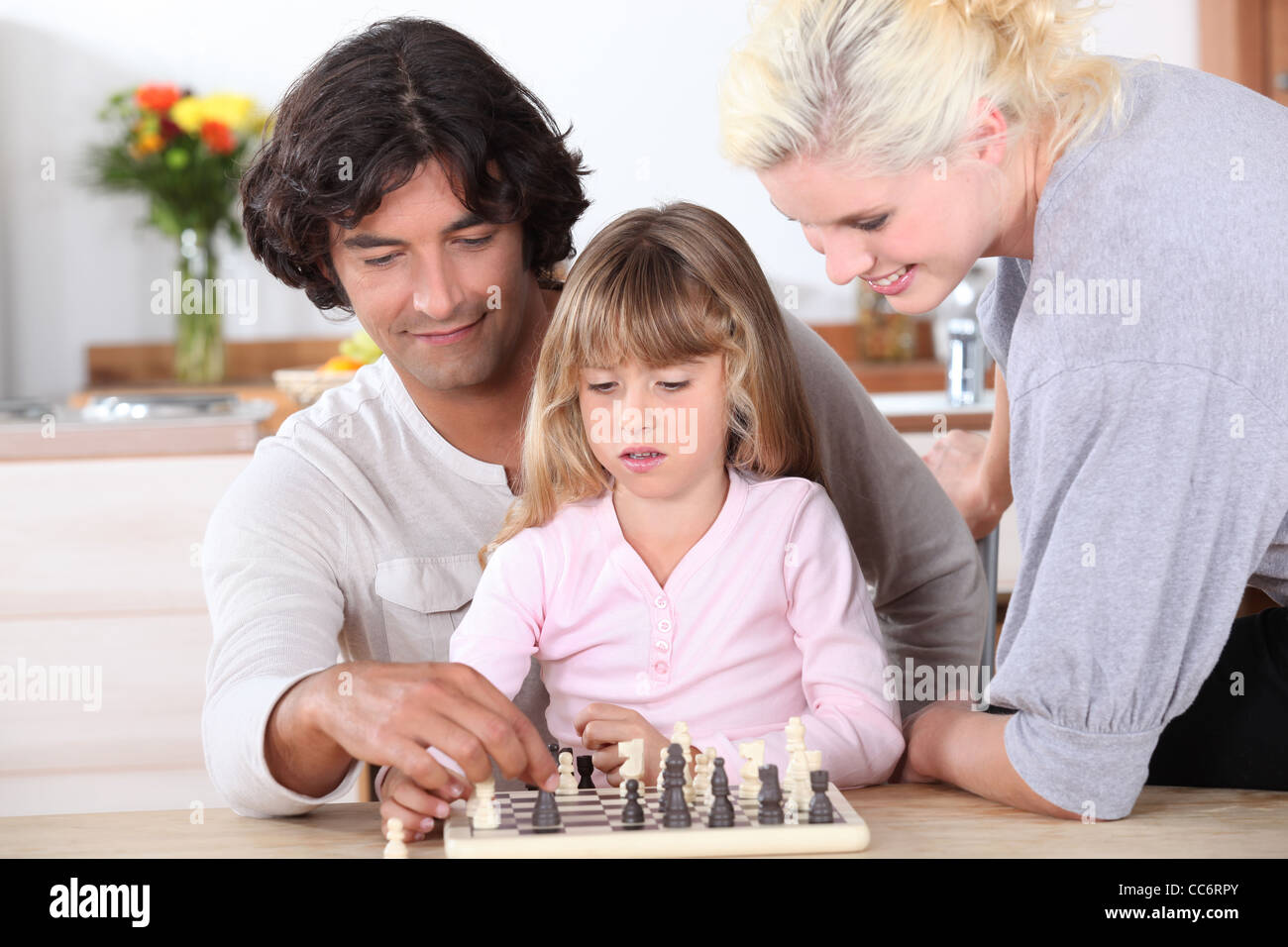 Young family playing chess Stock Photo - Alamy